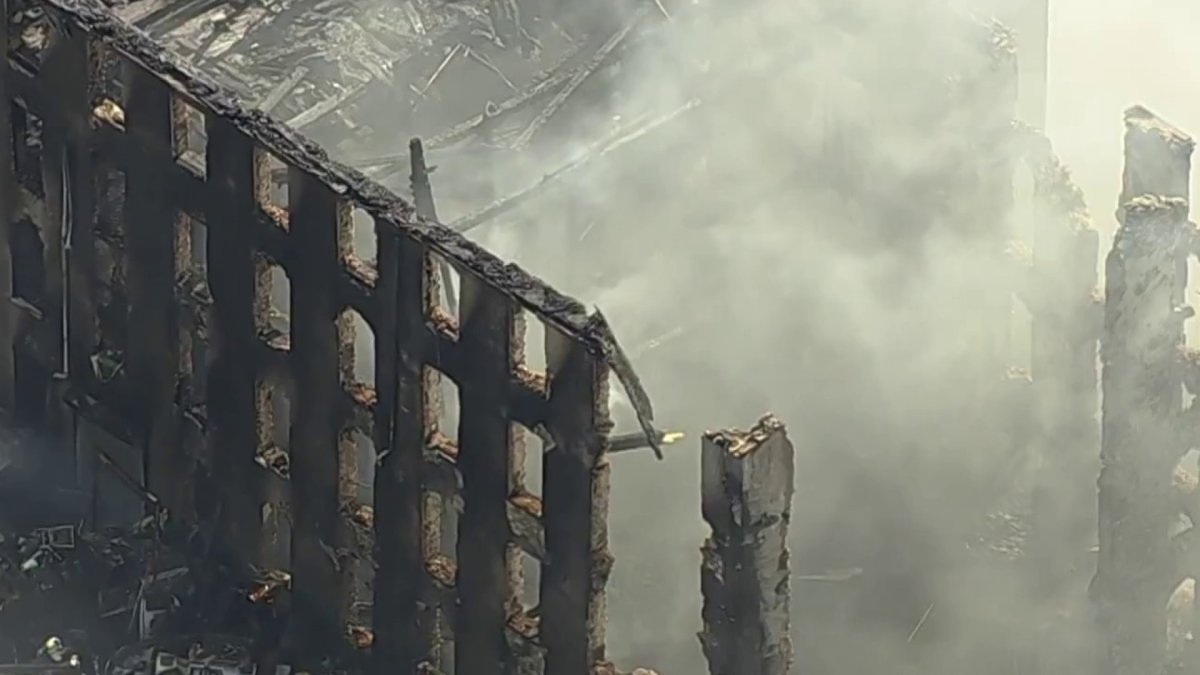 Intense fire burns through large building, torches cars, forces ...