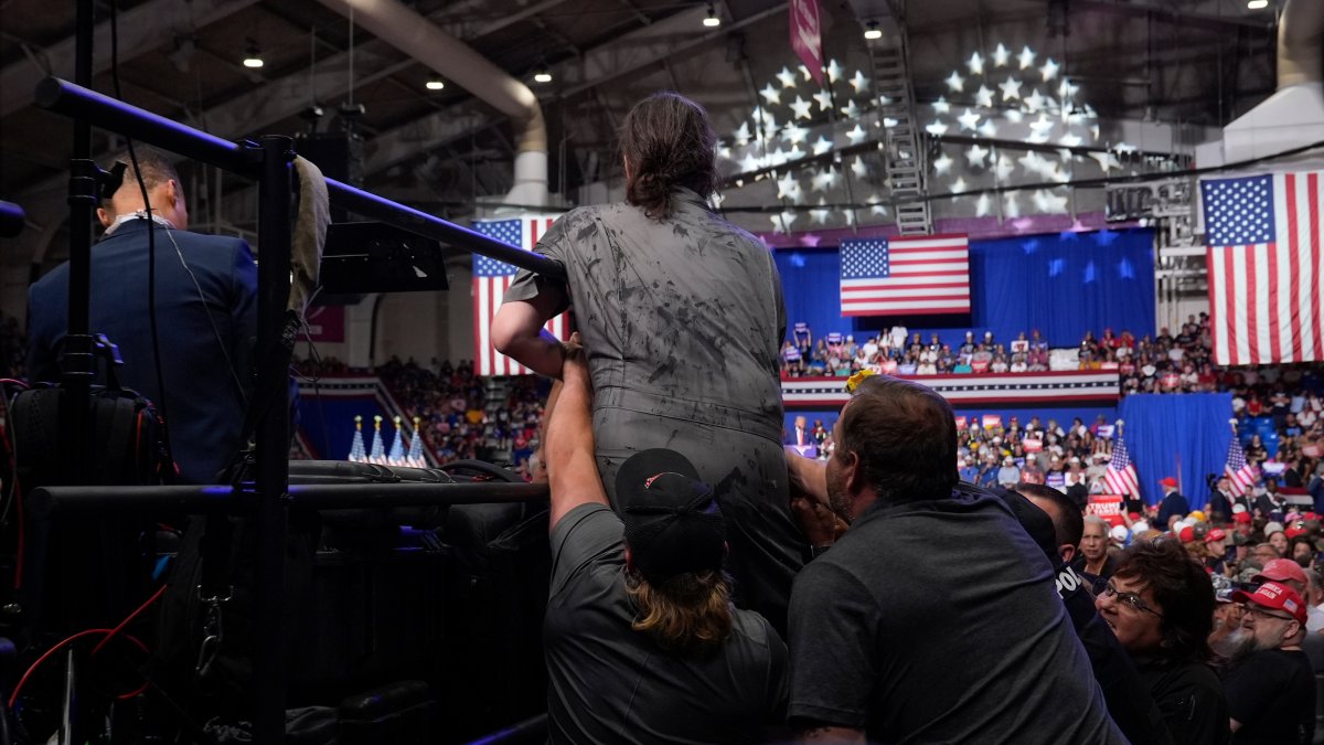 Man who climbed press riser at Trump rally tried to hang protest banner ...